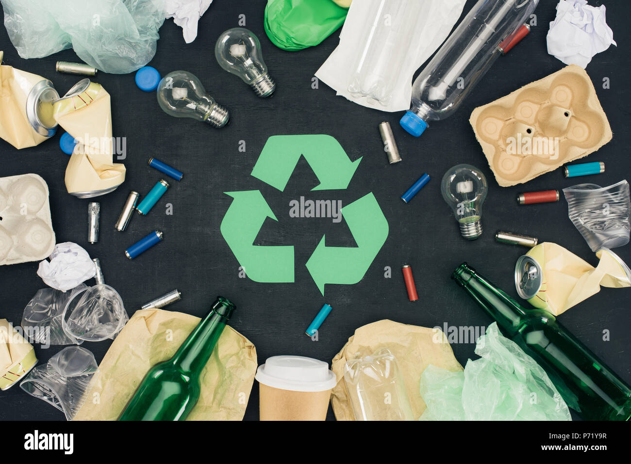 top view of various types of trash around recycle sign on black Stock ...