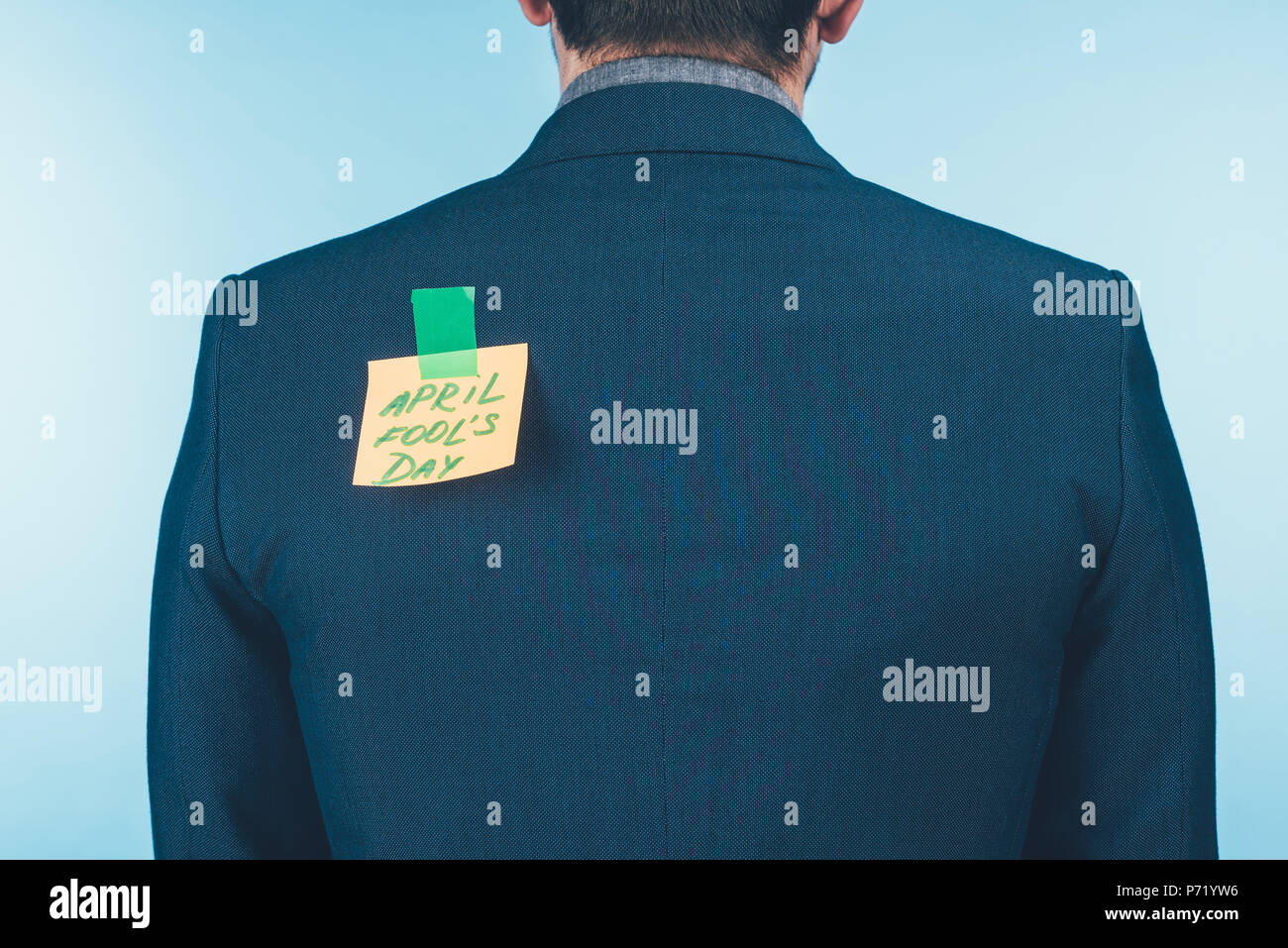 back view of businessman in suit with note with april fools day ...
