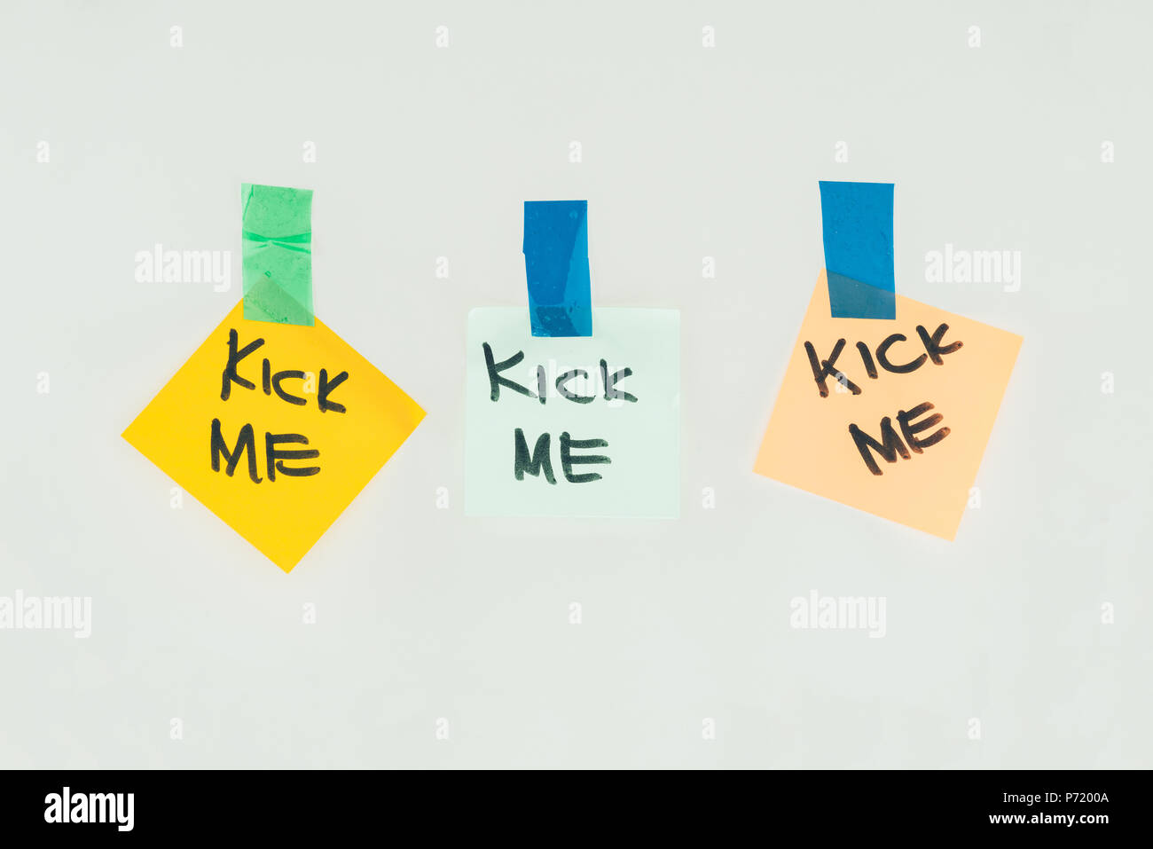 close up view of notes with kick me lettering and sticky tape isolated ...