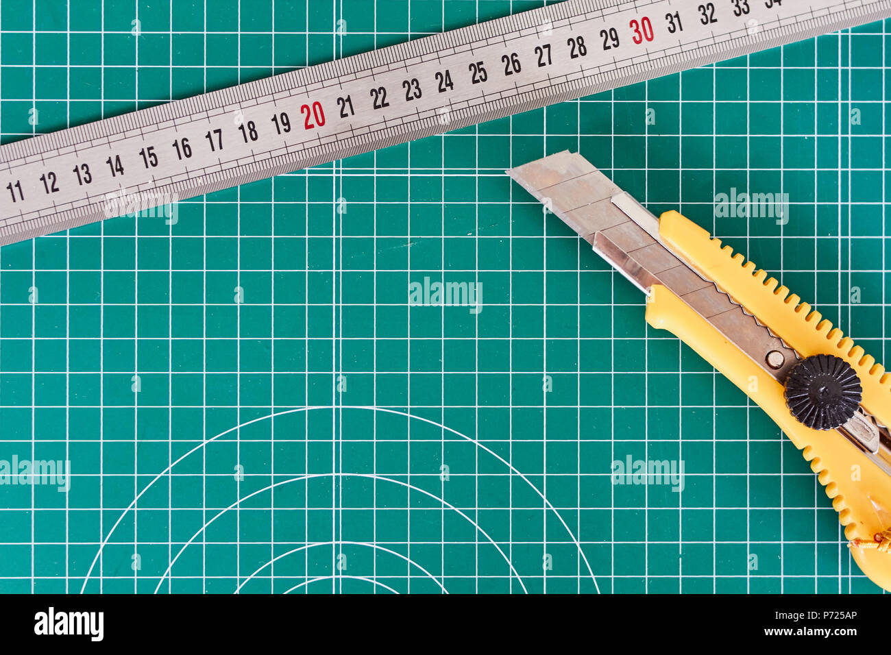 cutter and ruller and green cutting mat background Stock Photo - Alamy