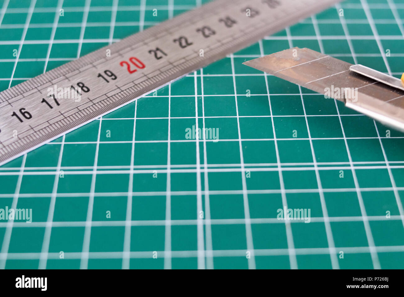 cutter and ruller and green cutting mat background Stock Photo - Alamy