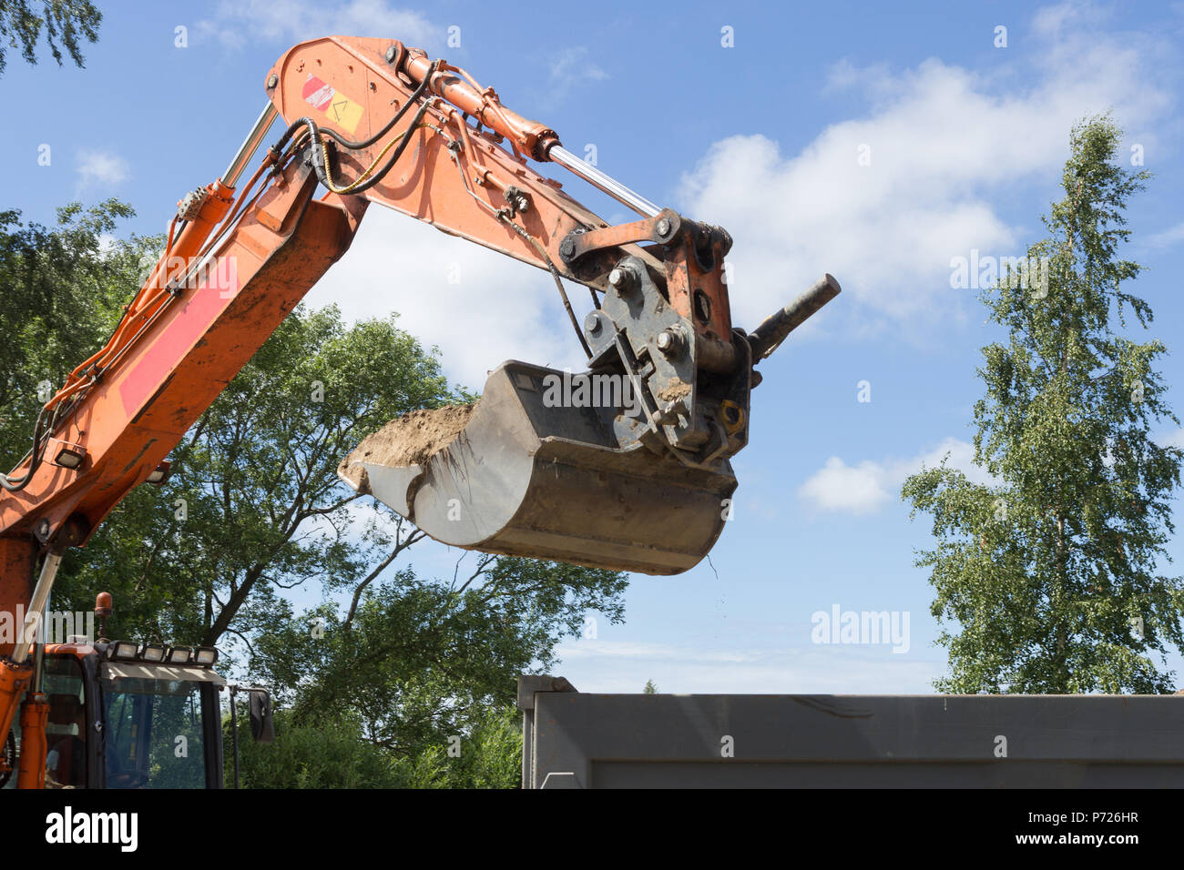 excavator loading ground to tipper truck on the street reconstruction ...