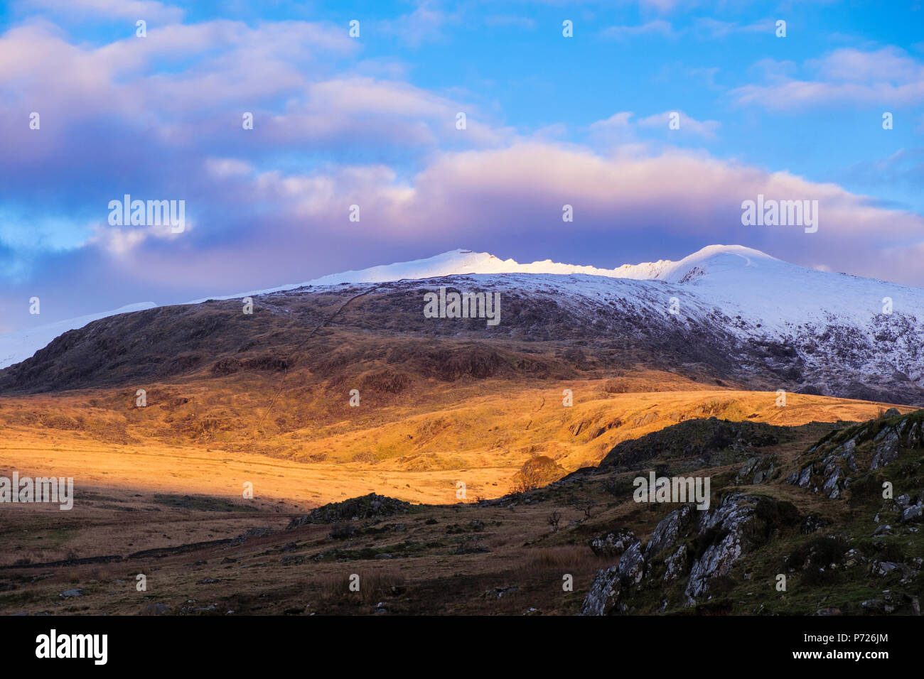 Late afternoon view to snow capped Mount Snowdon in winter in Snowdonia ...