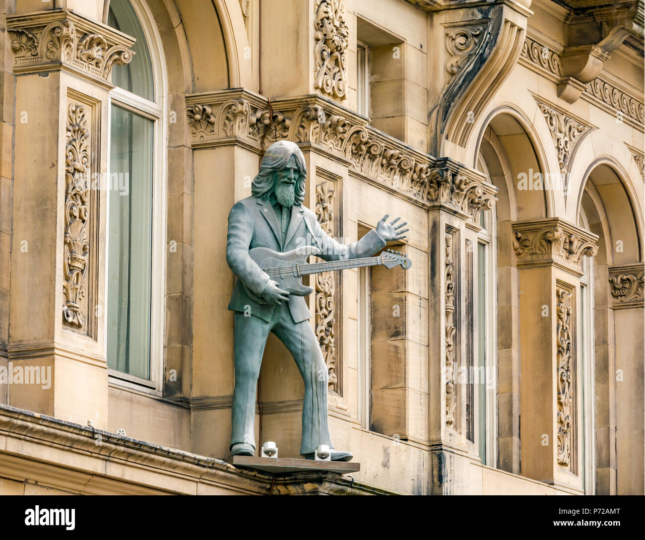 Statue of George Harrison playing a guitar outside Hard Day's Night ...