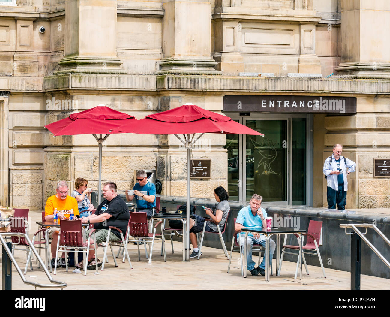 People sitting in outdoor cafe at entrance to Liverpool Central Library ...