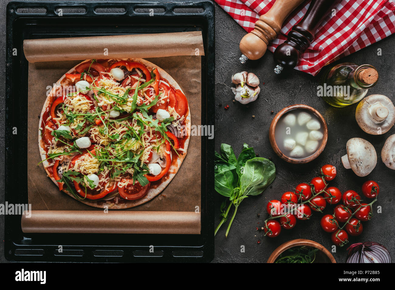 top view of freshly baked pizza with ingredients on concrete table ...