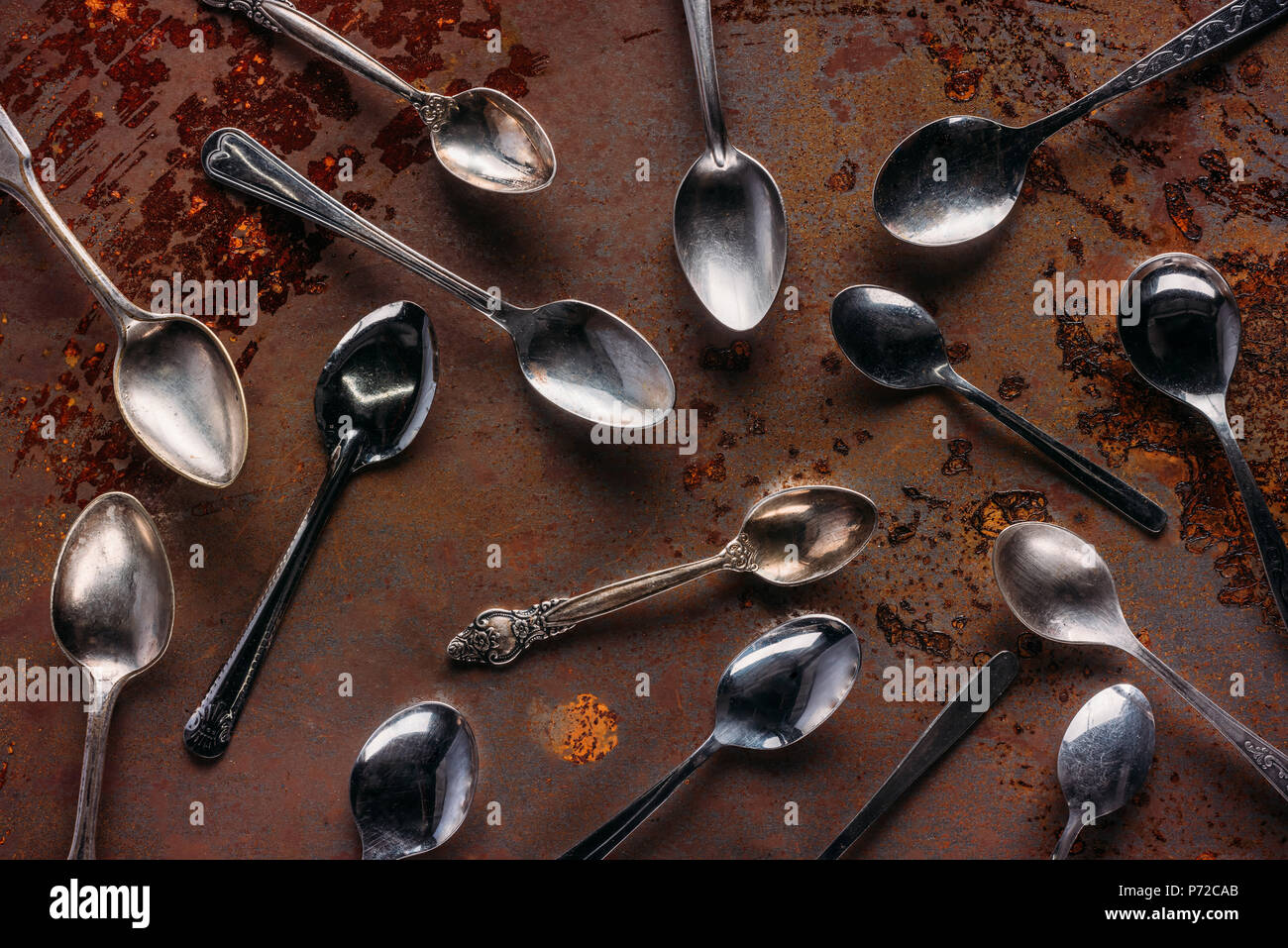 Vintage metal spoons on rusted background Stock Photo - Alamy