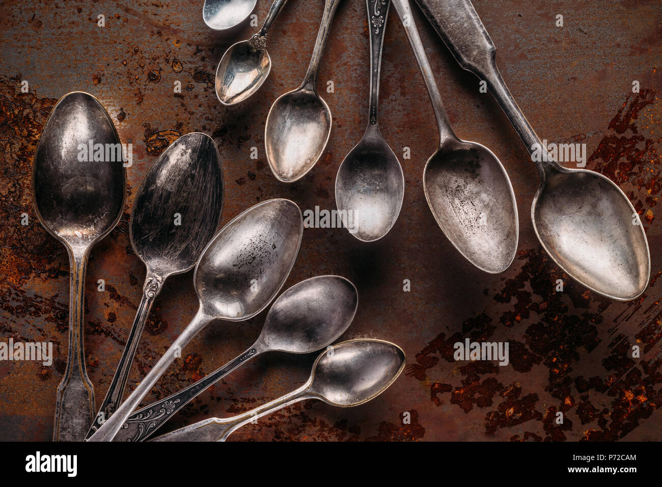 Old metal spoons on rusted background Stock Photo - Alamy