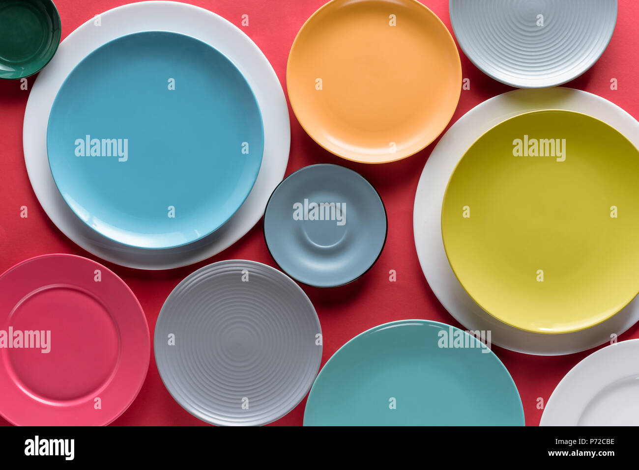 Stacks of colorful porcelain plates on red background Stock Photo - Alamy