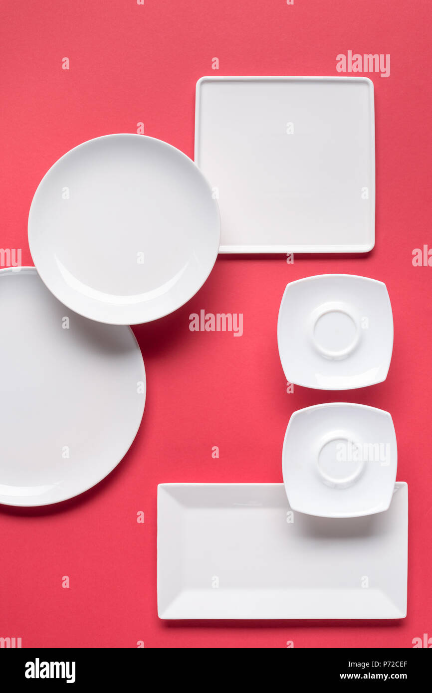 Composition of various white plates on red background Stock Photo - Alamy