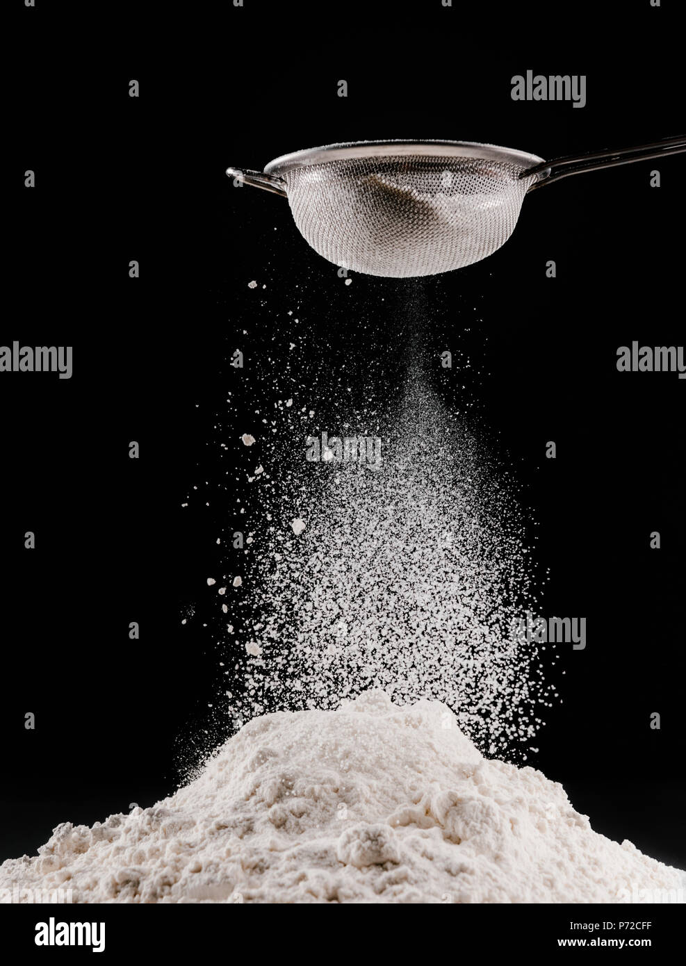 flour falling from sieve on pile isolated on black Stock Photo - Alamy