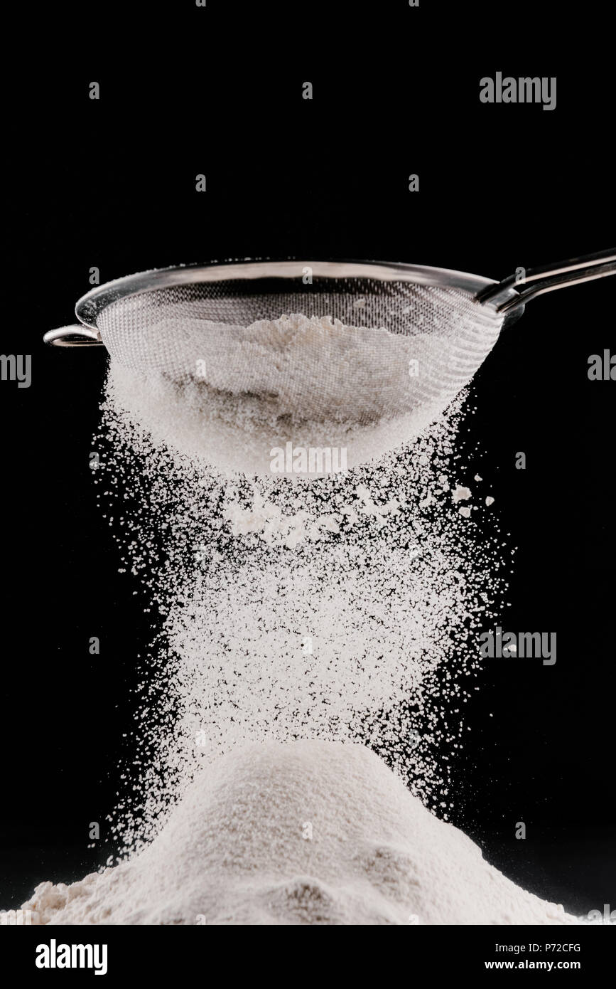 white flour falling from sieve on pile isolated on black Stock Photo ...