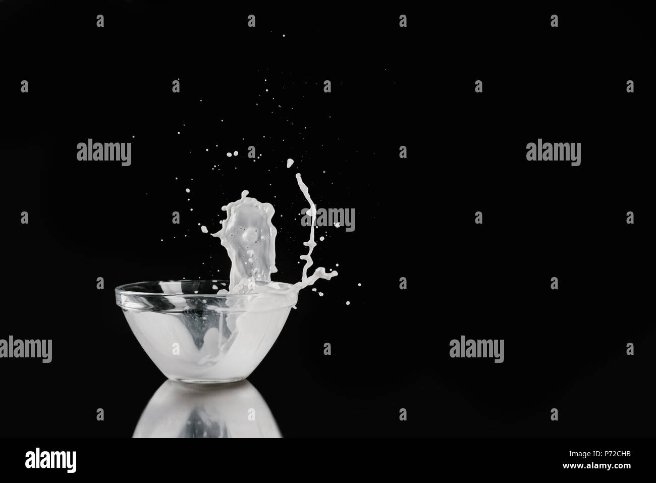 milk pouring out from bowl on black reflecting tabletop Stock Photo - Alamy