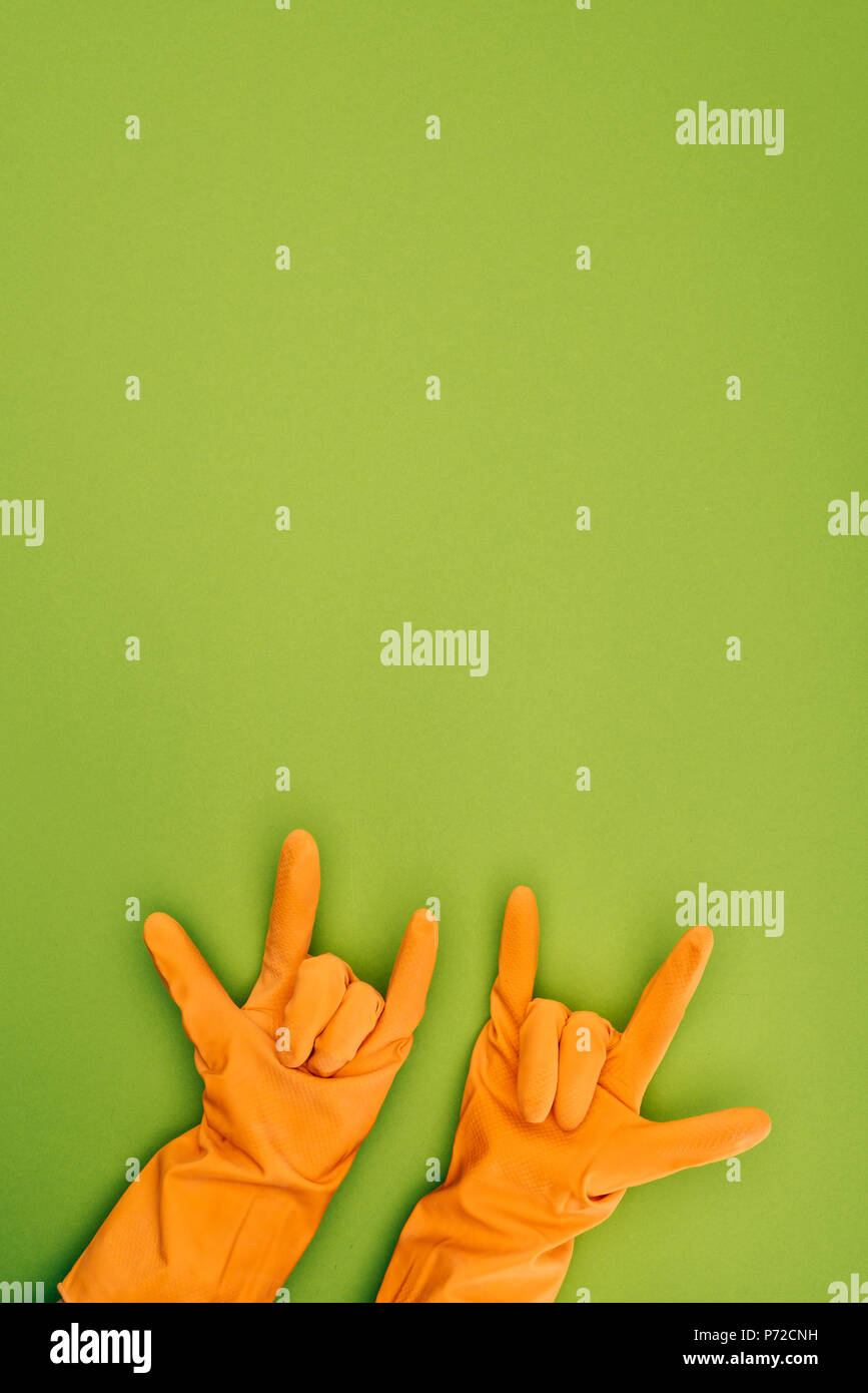 cropped image of woman showing rock signs in rubber protective gloves ...