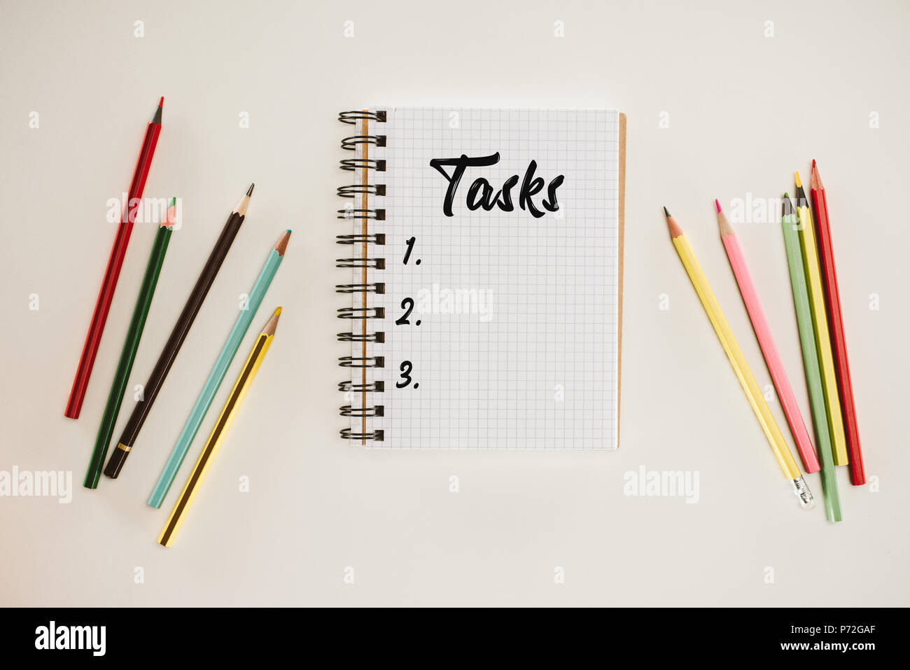 top view of notepad with blank tasks list lettering and colorful ...