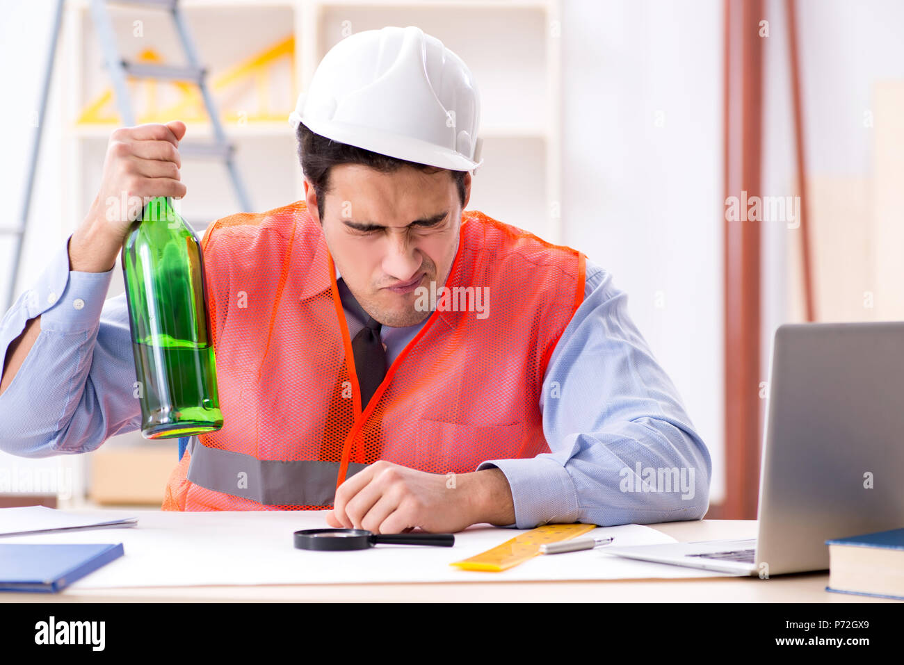 Drunk engineer working in the workshop Stock Photo - Alamy