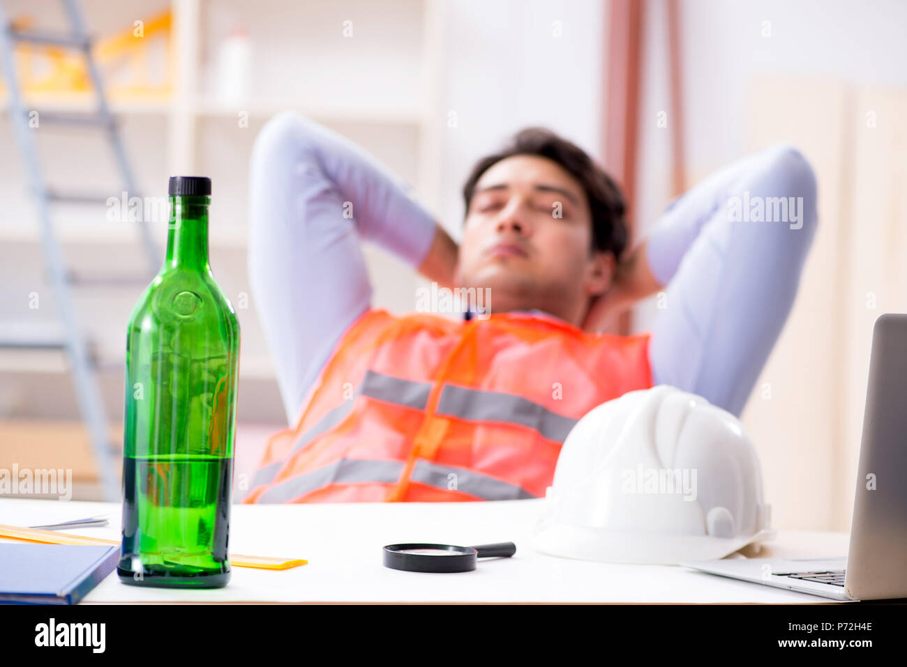 Drunk engineer working in the workshop Stock Photo - Alamy