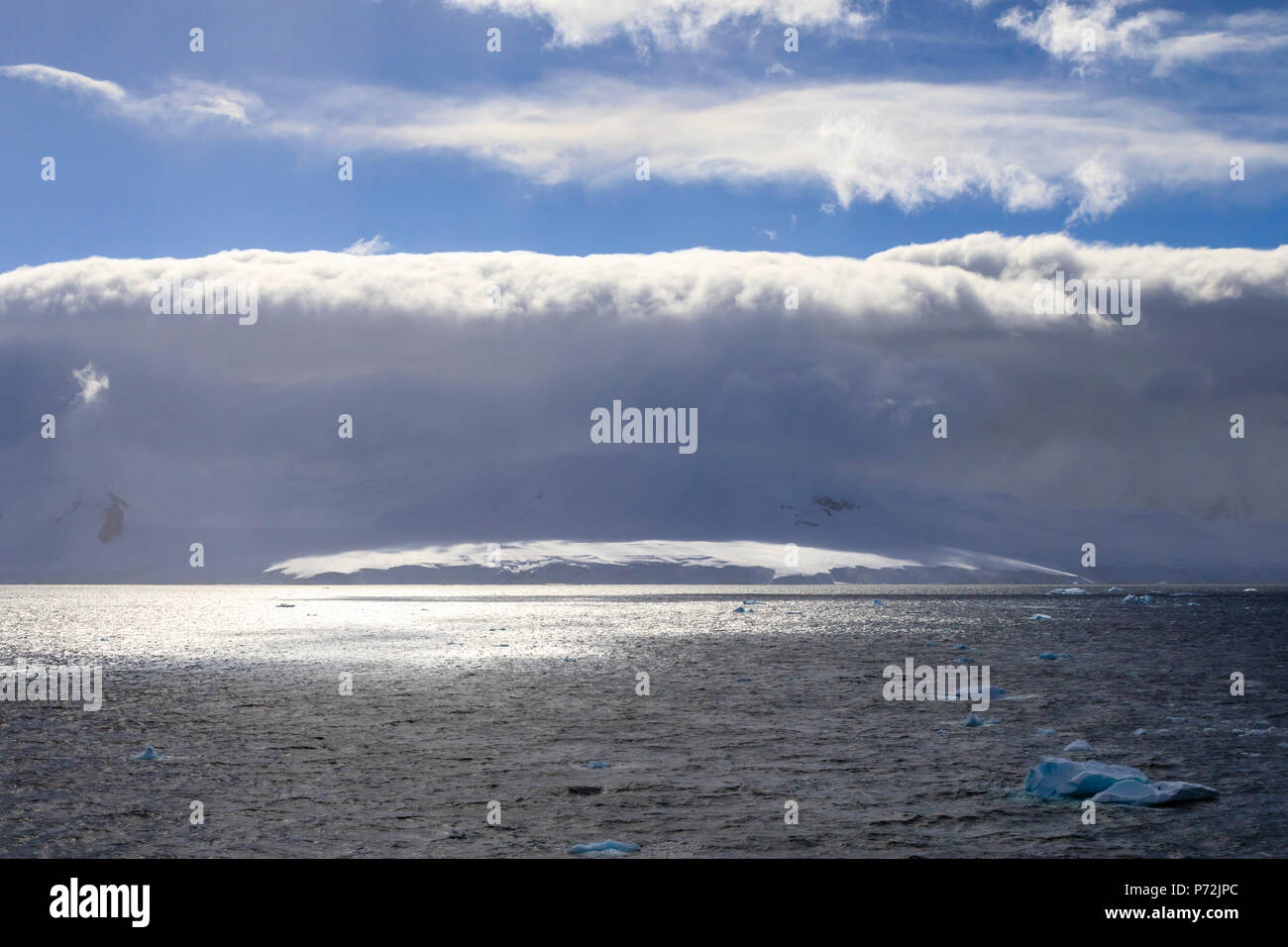 Arcus cloud over the mountains of the Gerlache Strait, blue sky ...
