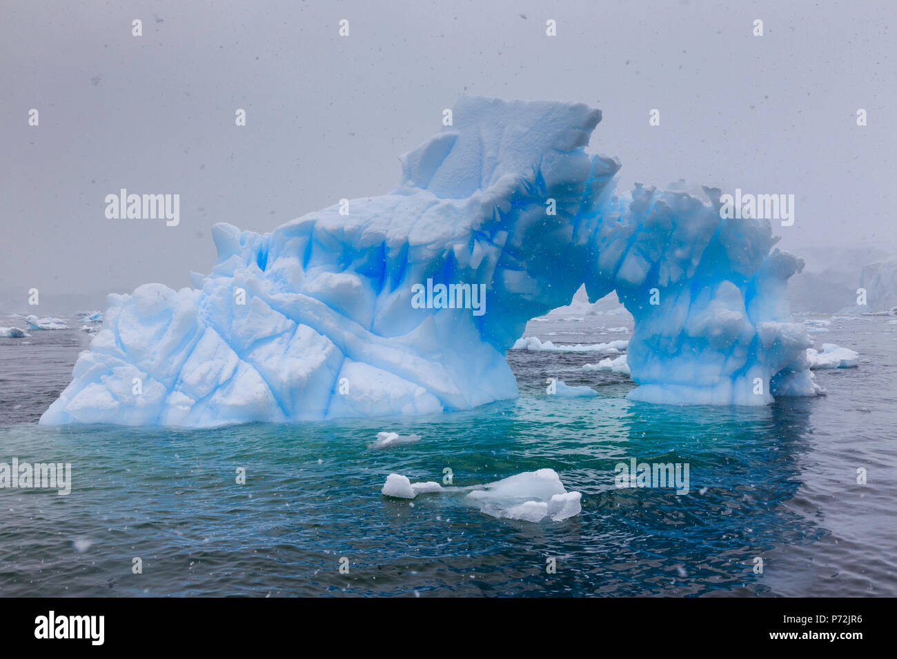 Blue iceberg arch in snowy weather, from sea level, Waterboat Point ...