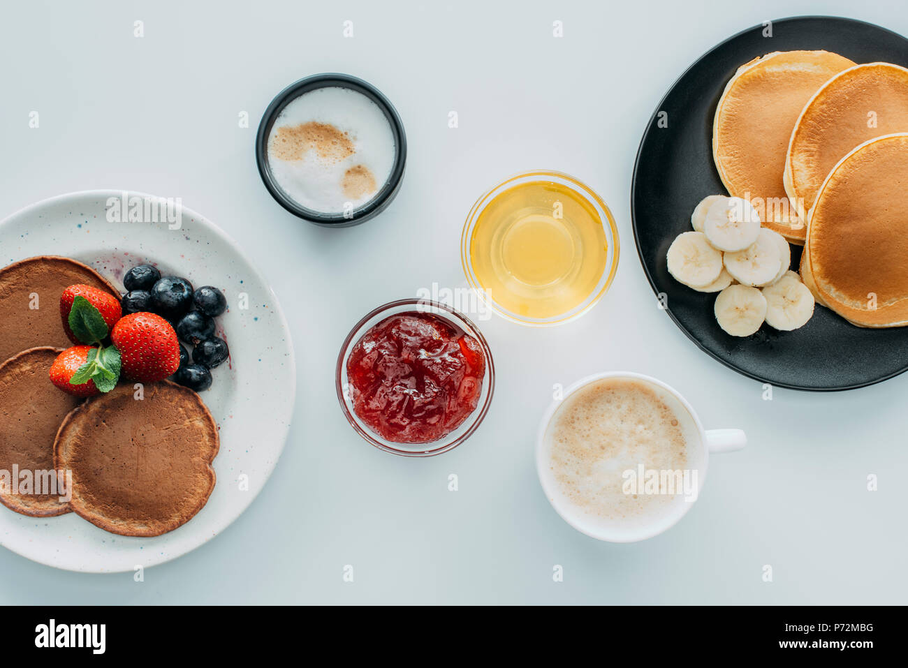 top view of breakfast for two with pancakes and coffee on white table ...