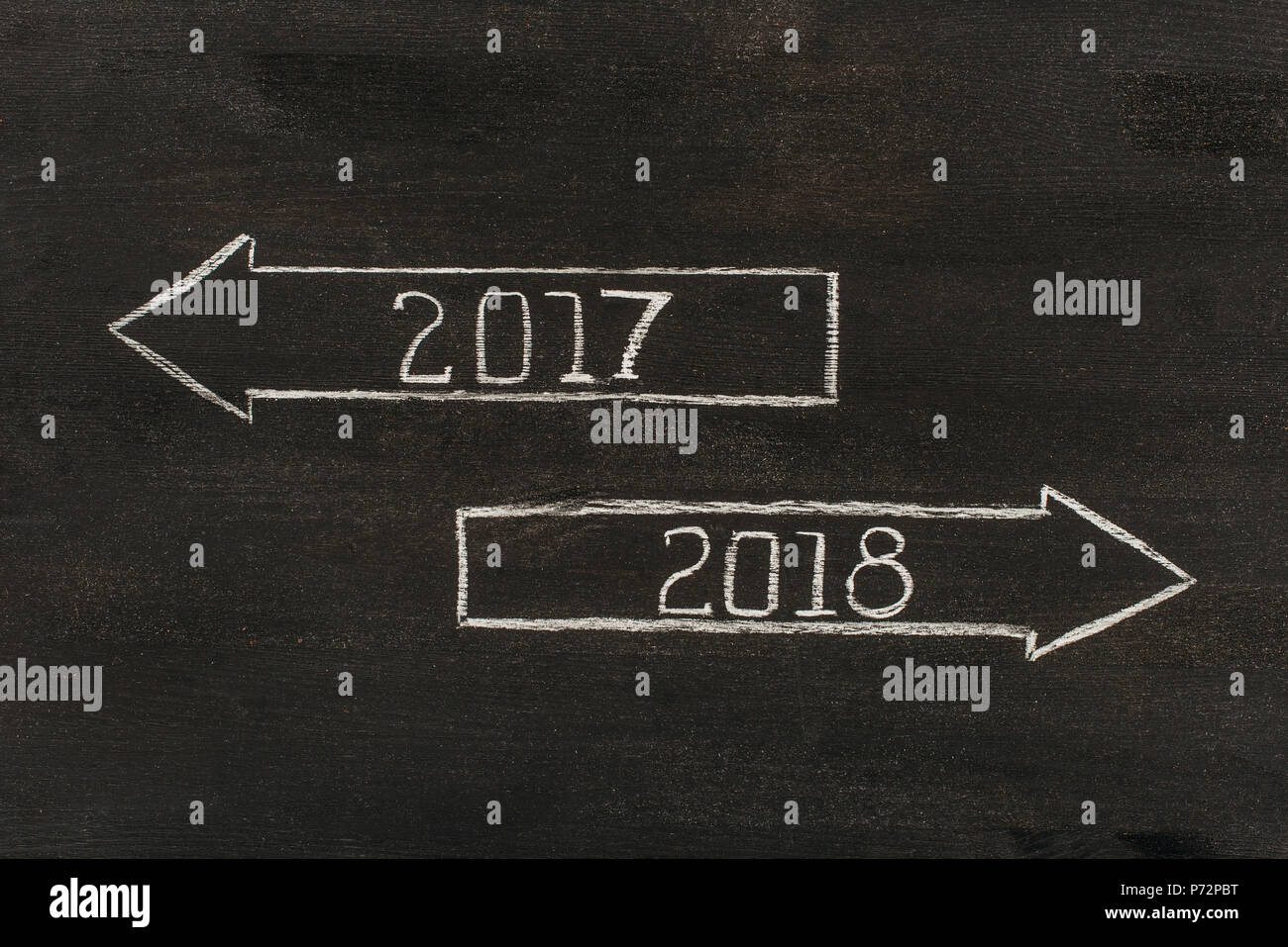 top view of arrows with 2017, 2018 year signs on dark wooden tabletop ...