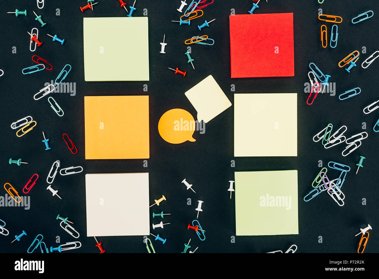 top view of speech bubbles, colorful paper clips and blank notes on ...