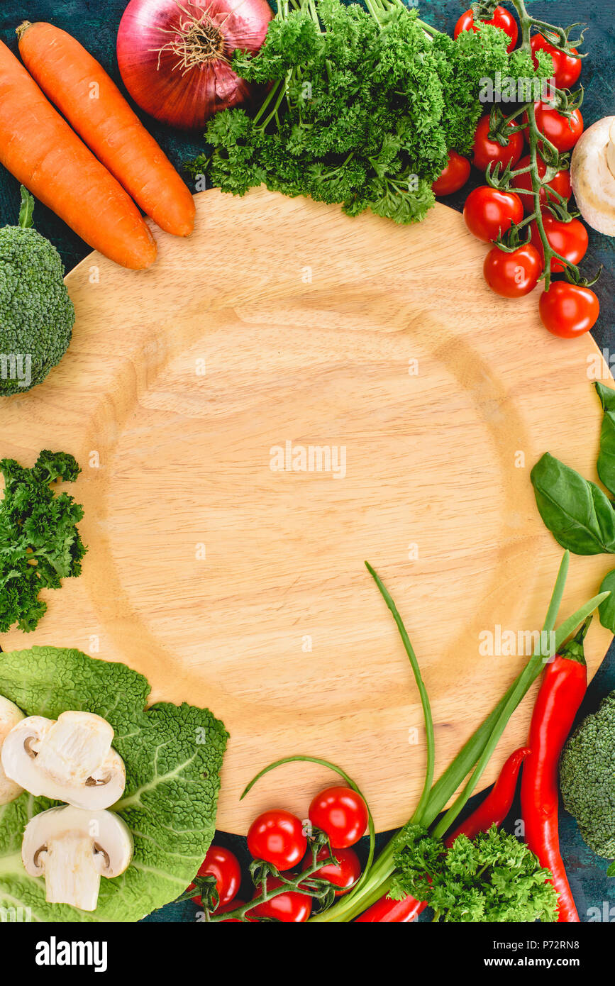 top view of fresh healthy raw vegetables and empty wooden plate Stock ...