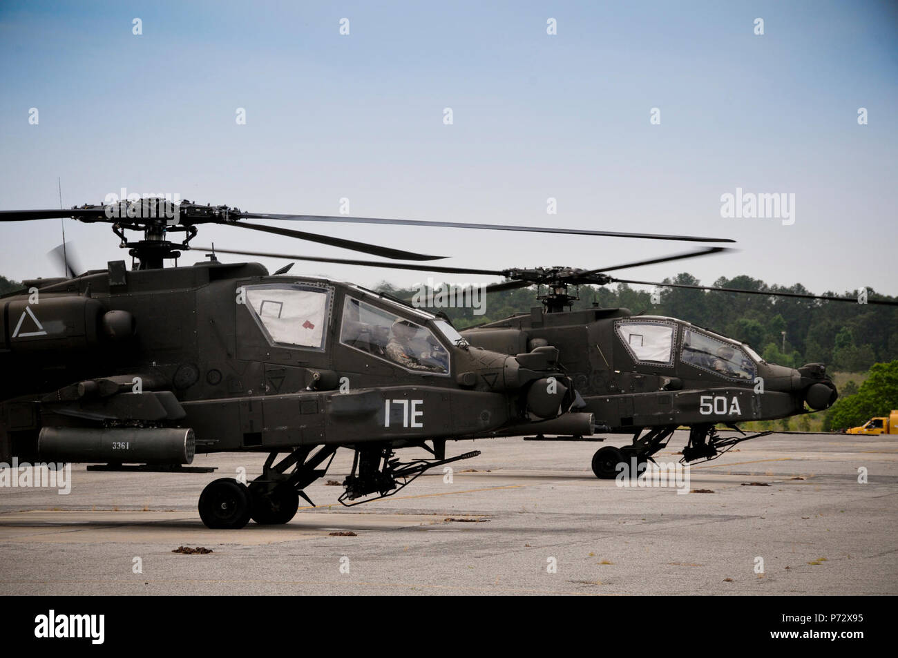 Two AH-64D Apache helicopters wait in parking at Ech Stagefield, Fort ...
