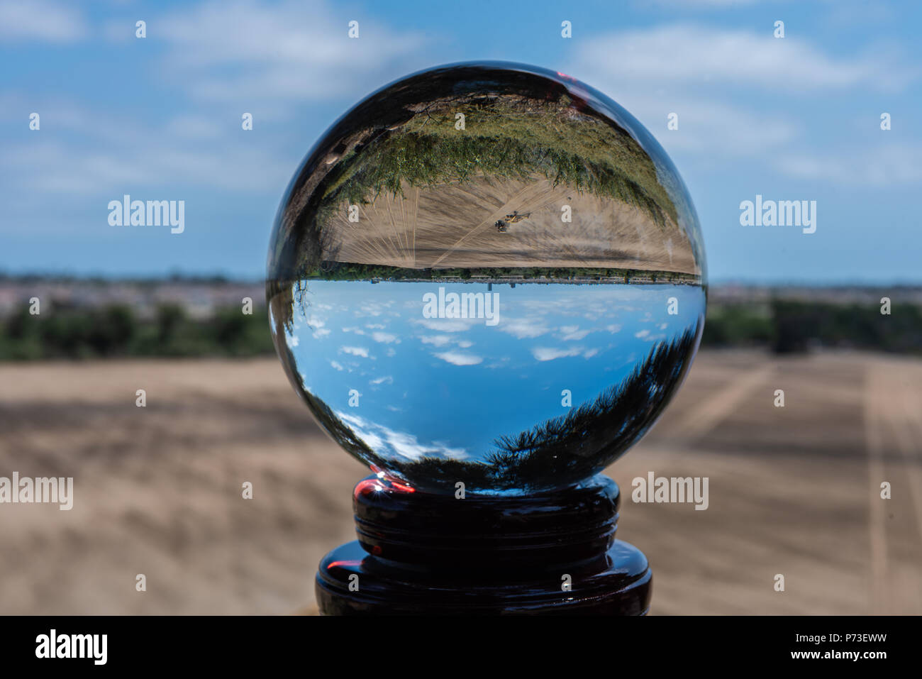 Fallow farm field being worked by tractor as seen through upside down ...