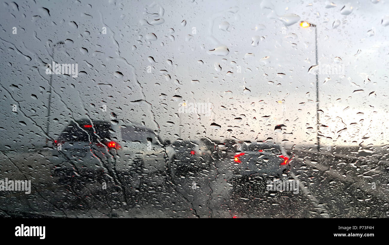 Inside the car. Closeup rain water drops. car windshield view during ...