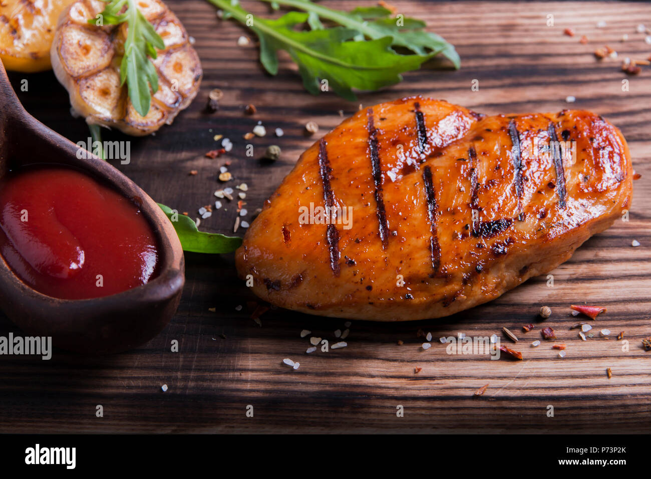 Grilled chicken fillet with sauce,garlic and lemon on wood Stock Photo ...