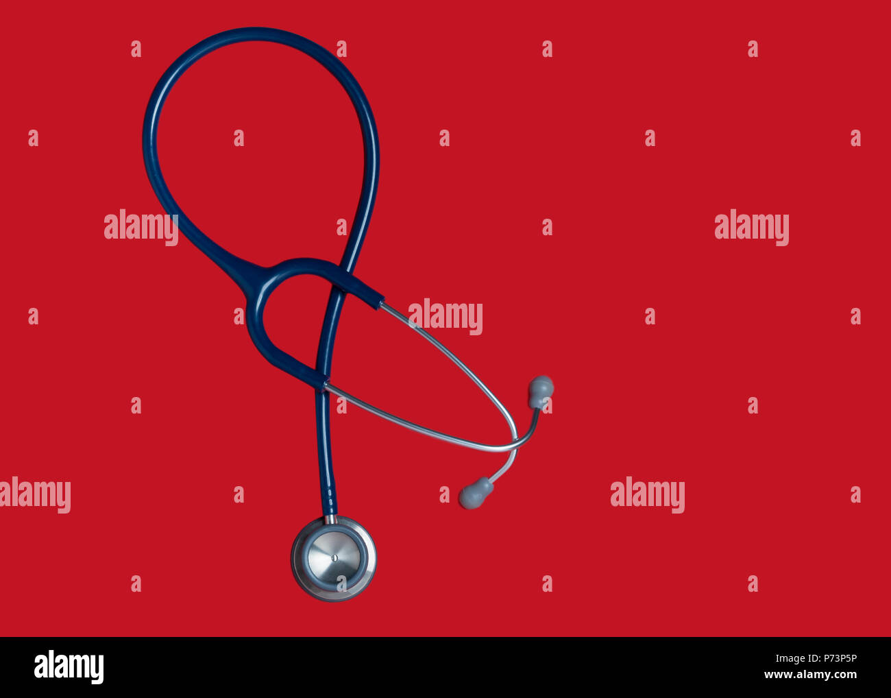 Top view blue stethoscope on red background. For check heart or health ...