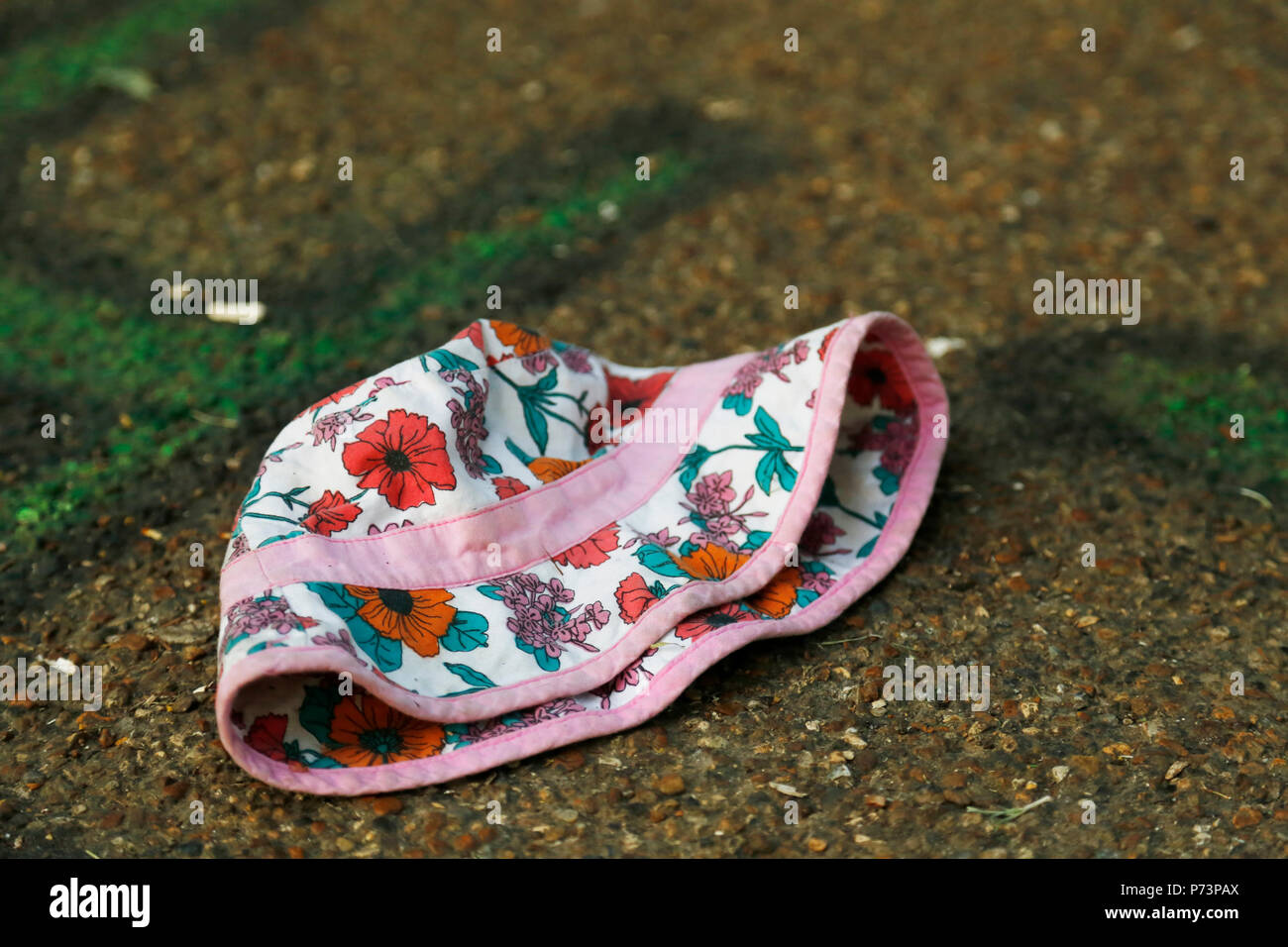 Discarded babies hat on path Stock Photo - Alamy