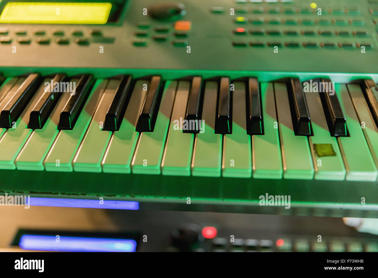 Keyboard of synthesizer in detail in tinted green Stock Photo - Alamy