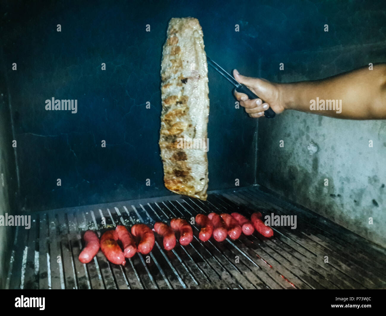 Hand grabbing a piece of meat cooking on a grill Stock Photo - Alamy