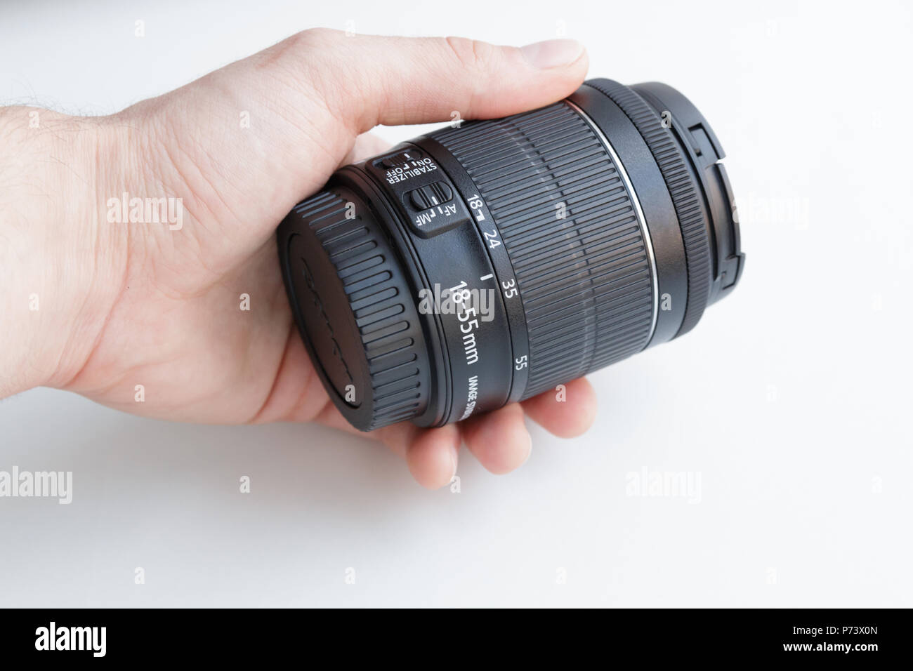 Hand holding camera lens on white background Stock Photo - Alamy