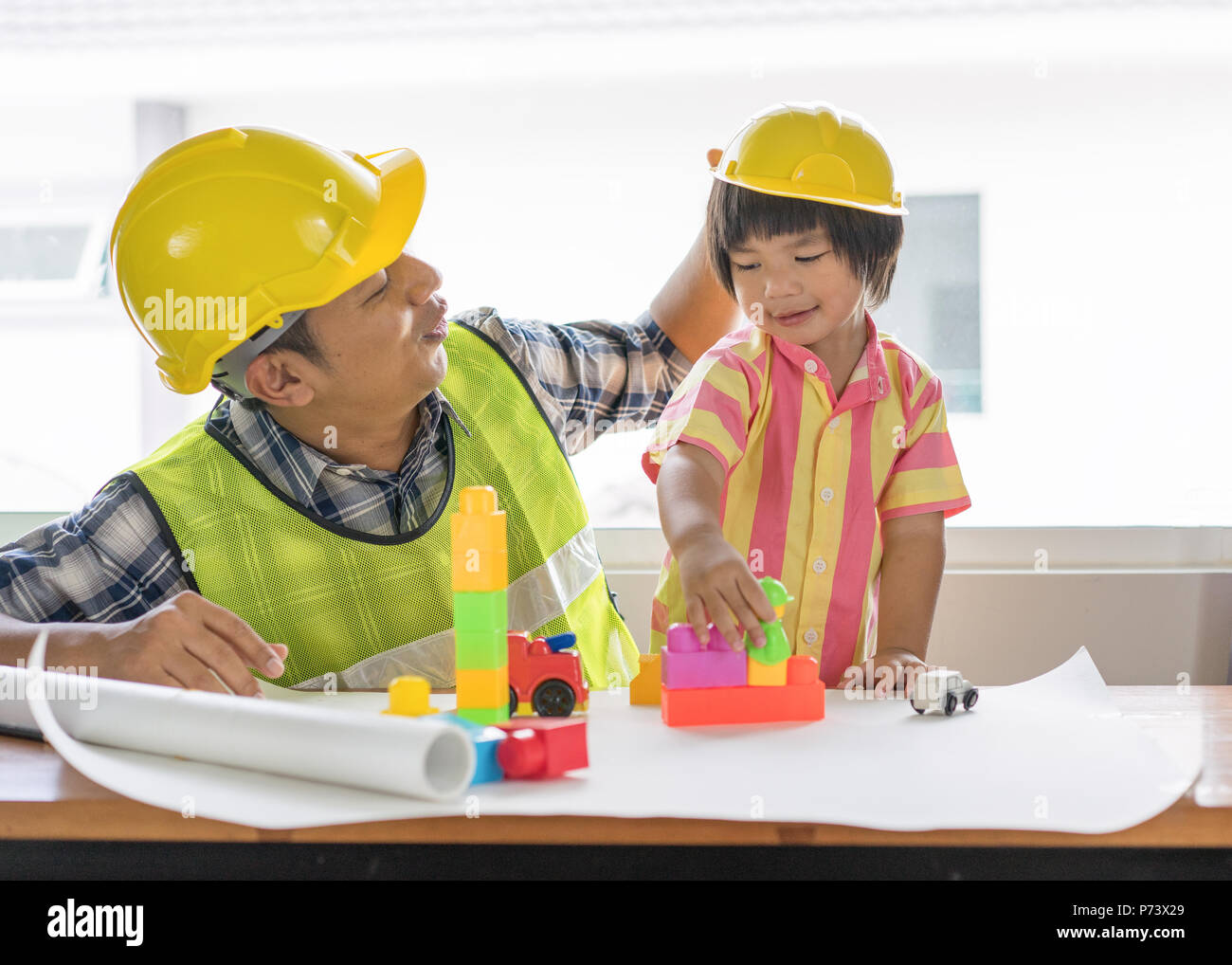 Architect working on blueprint. Architects workplace and asian little ...