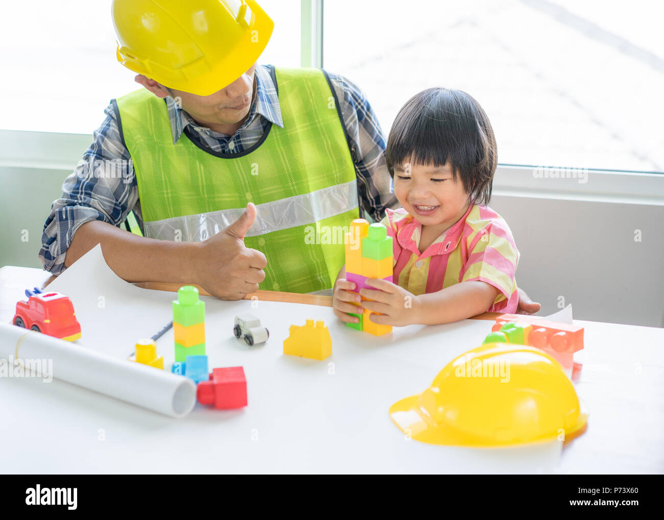 Architect working on blueprint. Architects workplace and asian little ...