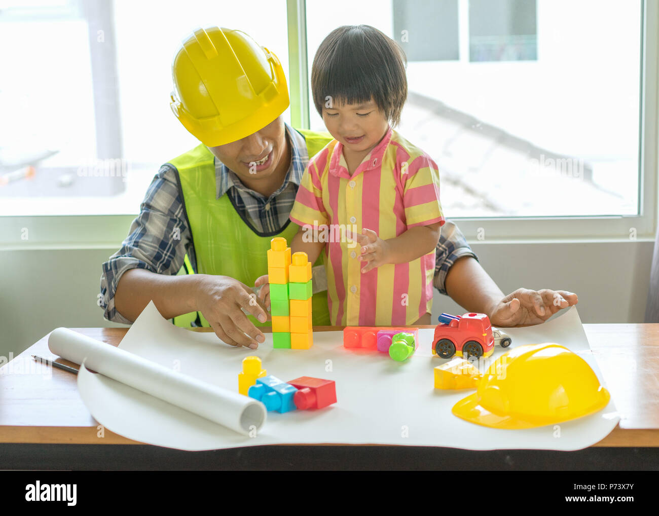 Architect working on blueprint. Architects workplace and asian little ...
