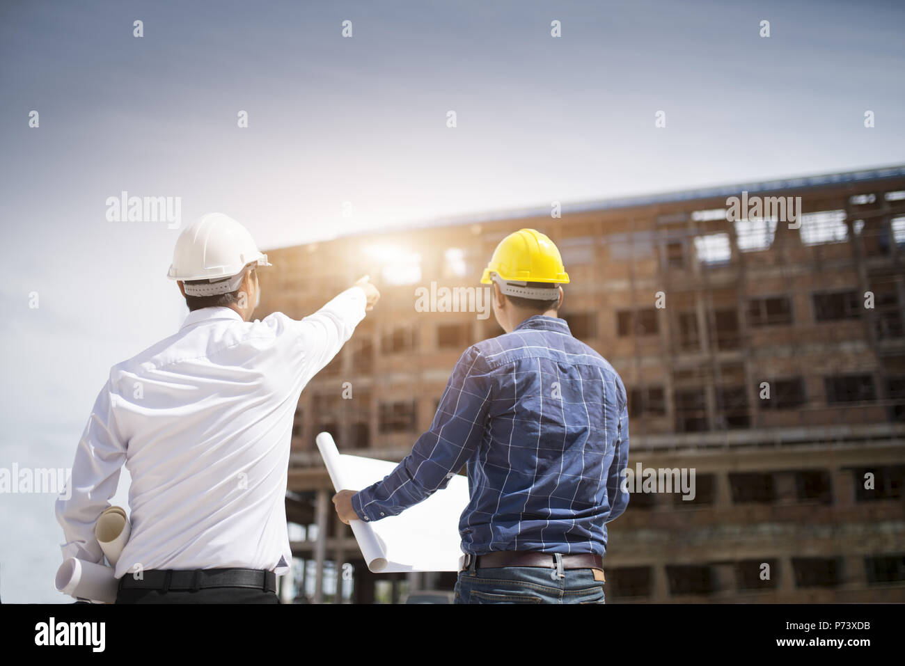 Construction engineers discussion with architects at construction site ...