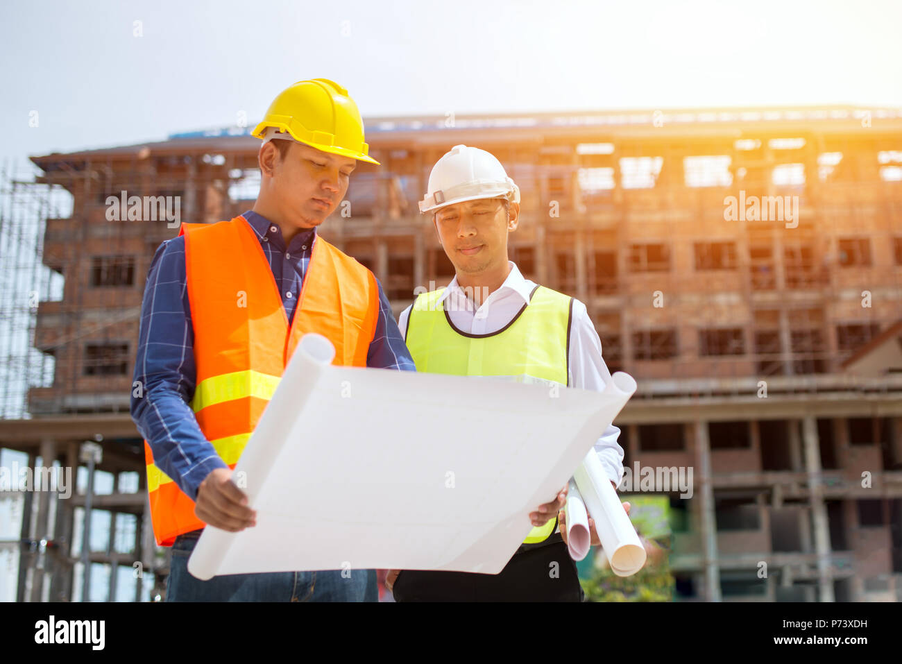 Construction engineers discussion with architects at construction site ...