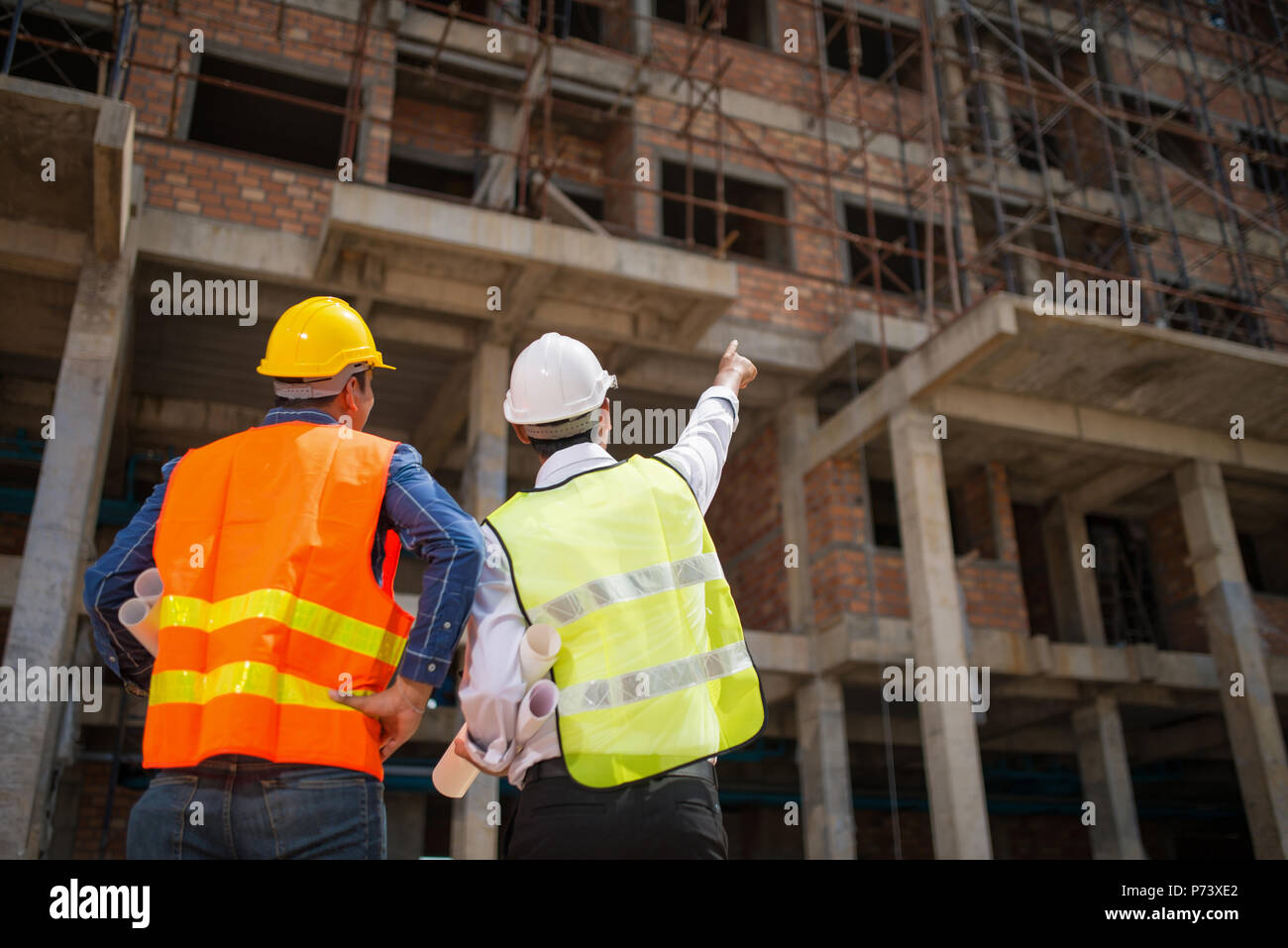 Construction engineers discussion with architects at construction site ...