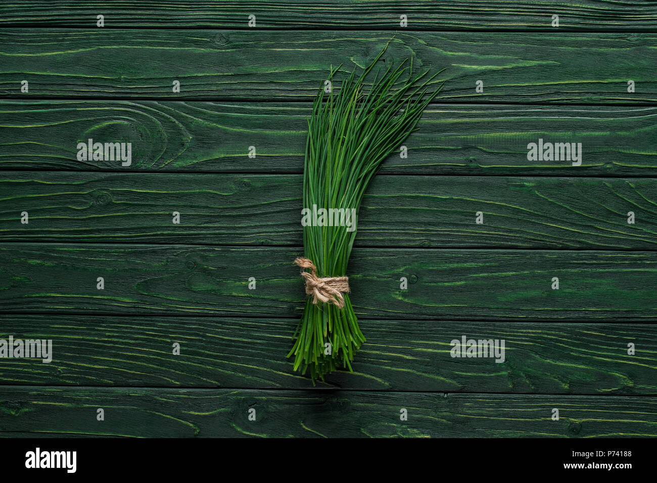 top view of bunch of chives on wooden table, healthy eating concept ...