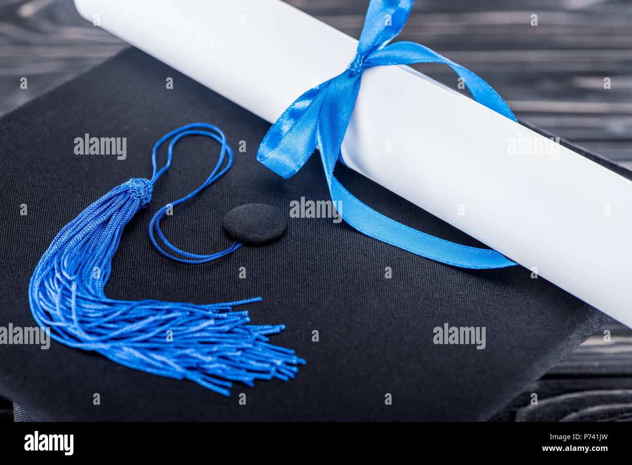High school concept with diploma and graduation cap on wooden table ...