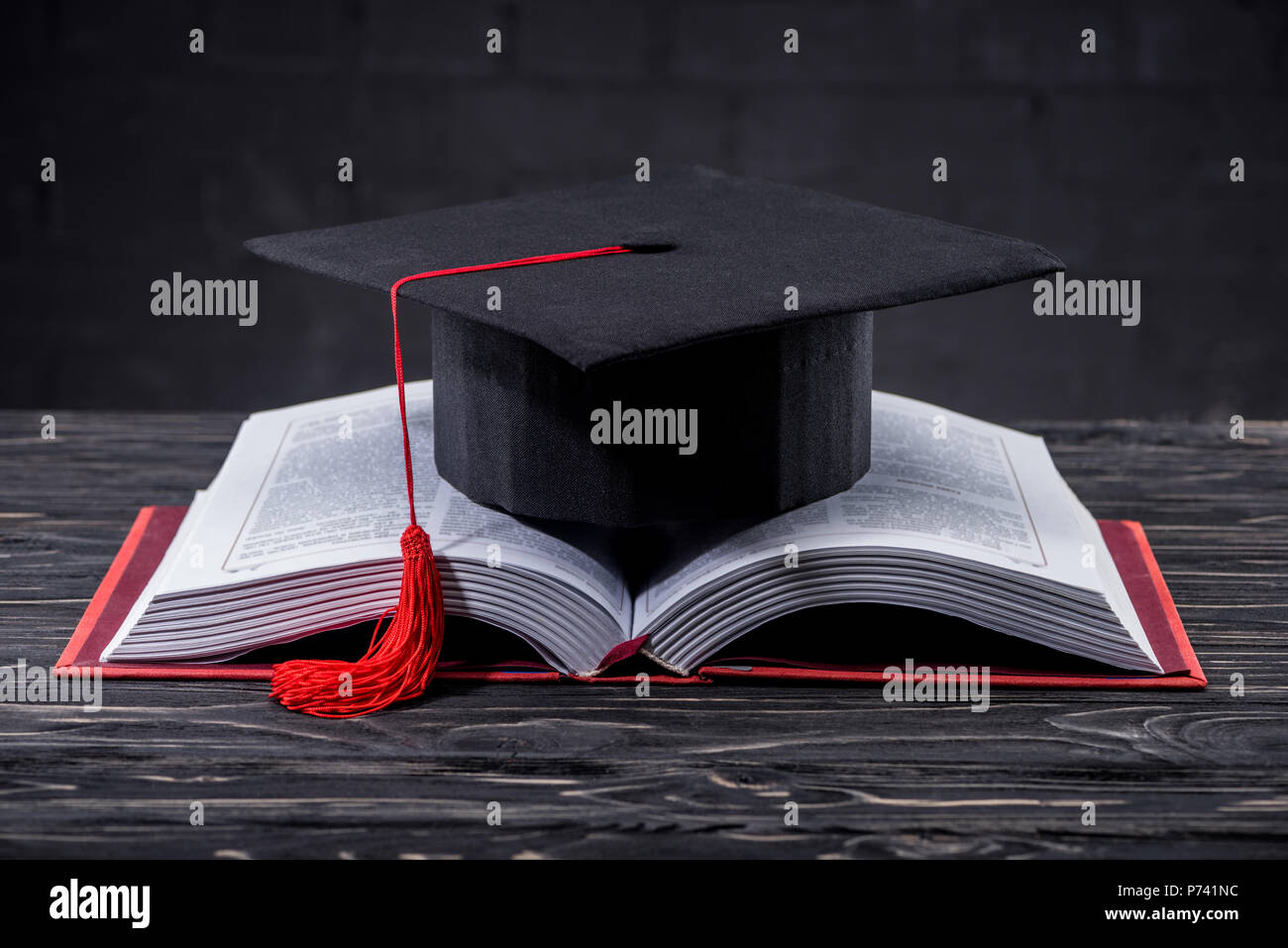 Open book with graduation cap on wooden table Stock Photo - Alamy