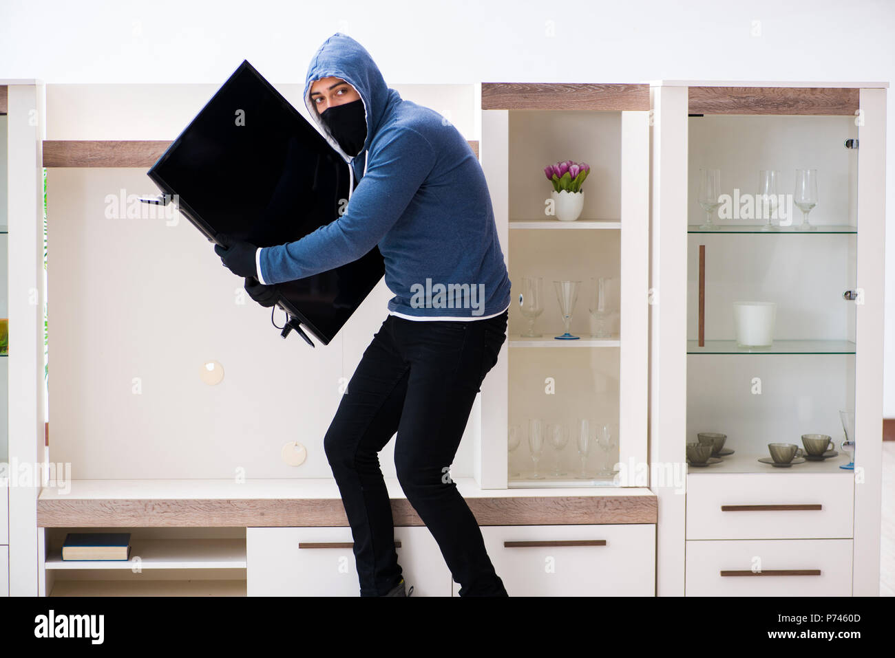 Man burglar stealing tv set from house Stock Photo - Alamy