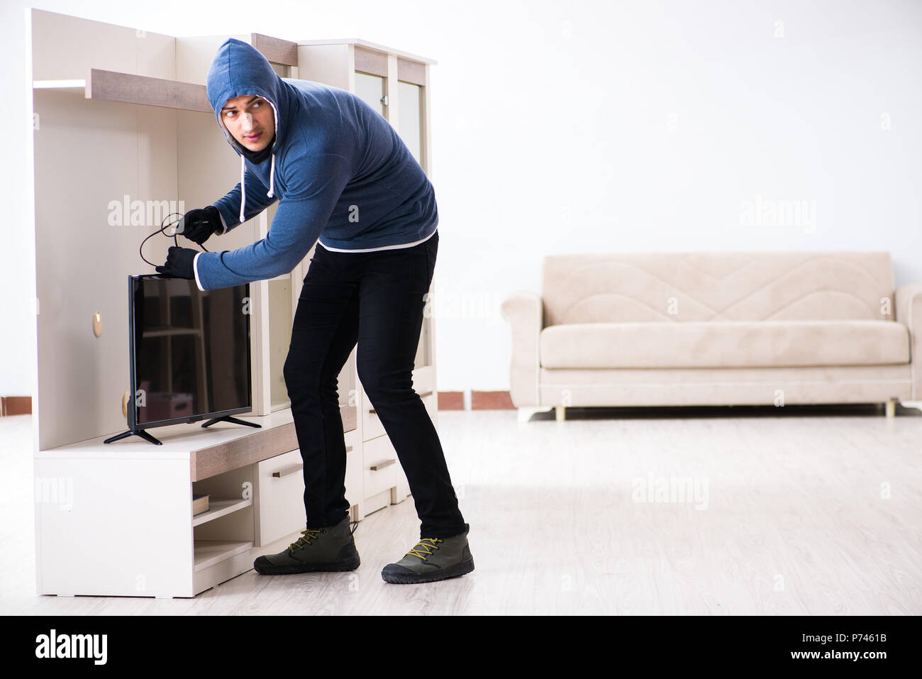 Man burglar stealing tv set from house Stock Photo - Alamy