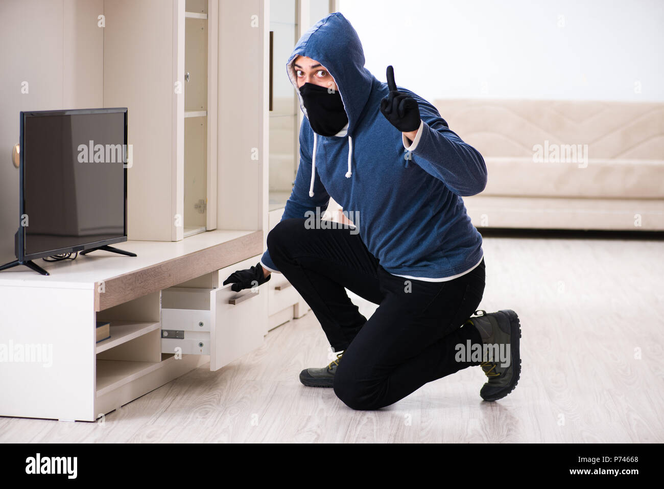 Man burglar stealing tv set from house Stock Photo - Alamy
