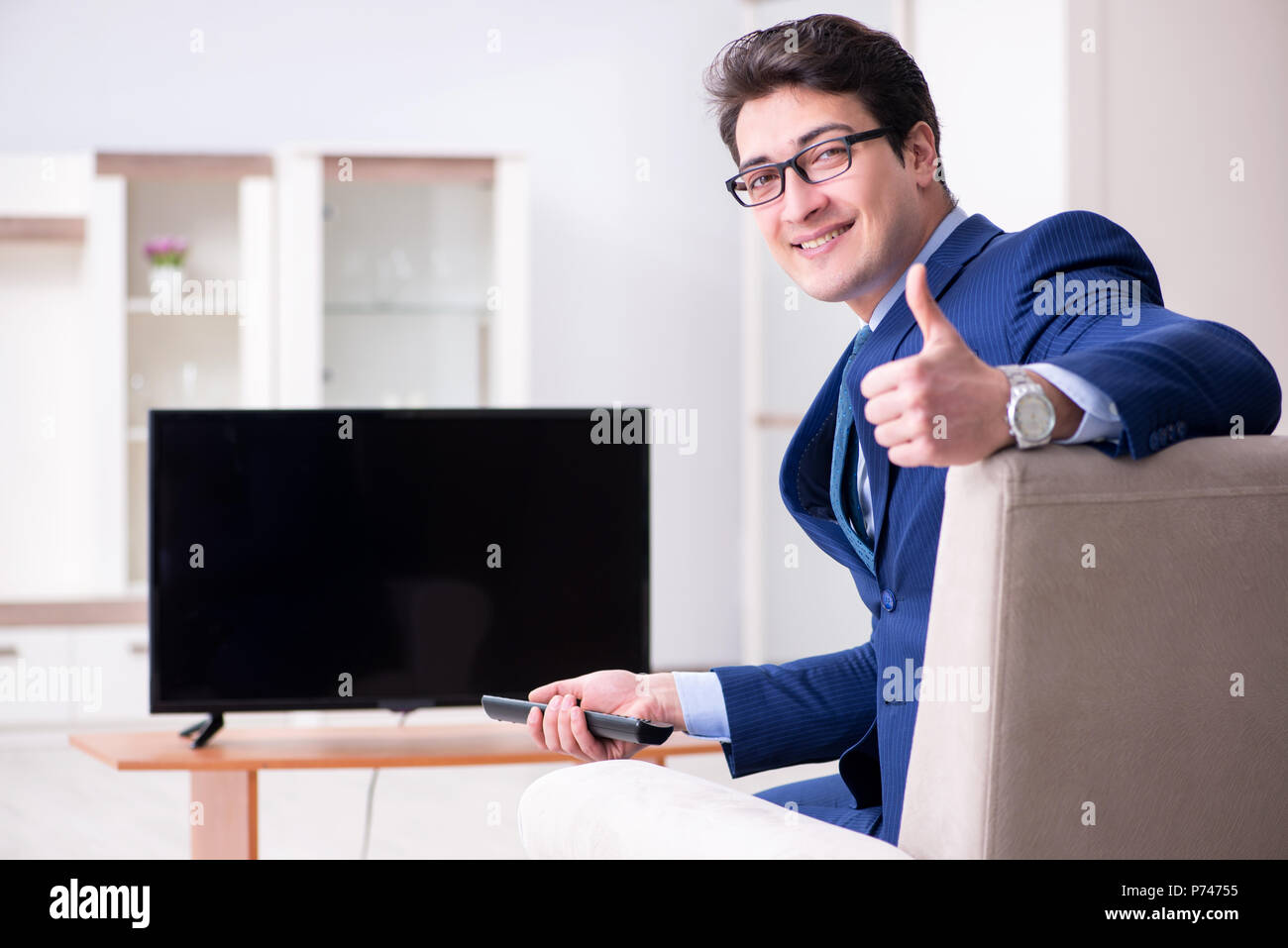 Businessman watching tv in the office Stock Photo - Alamy