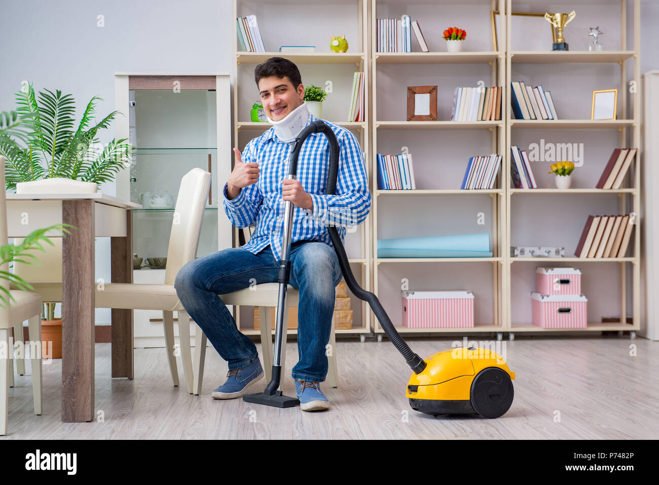 Injured man with neck injury vacuum cleaning house Stock Photo - Alamy